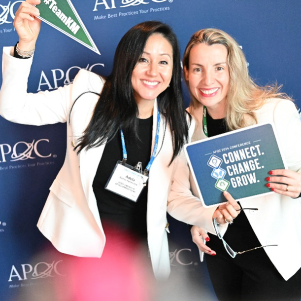 Two conference attendees posing for a photo celebrating the 2023 ...